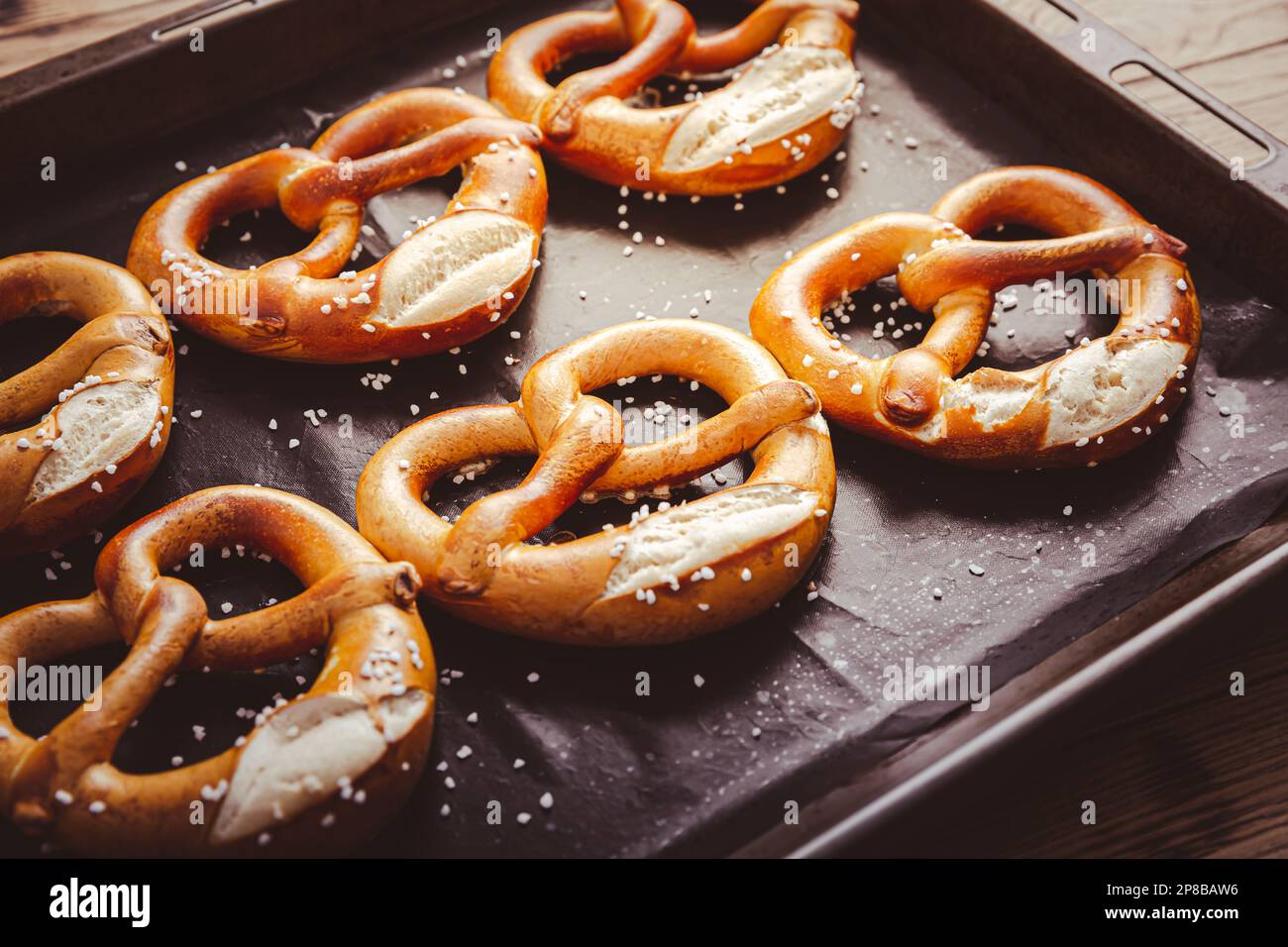 Fresh baked homemade German pretzel with sea salt on baking sheet ...