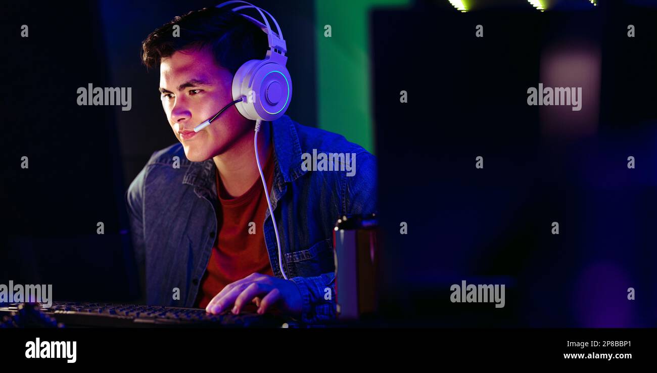 Young male player focusing on his computer screen as he plays a video ...
