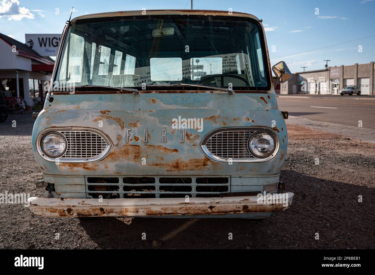 A blue ford falcon mini bus is parked in a desolate dirt lot Stock ...