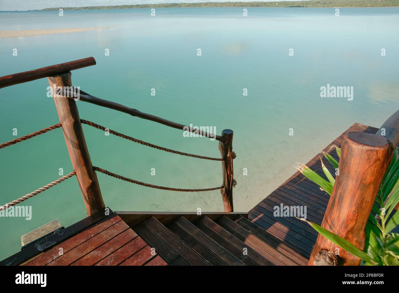 Rustic railing and steps down to turquoise tropical water Stock Photo ...