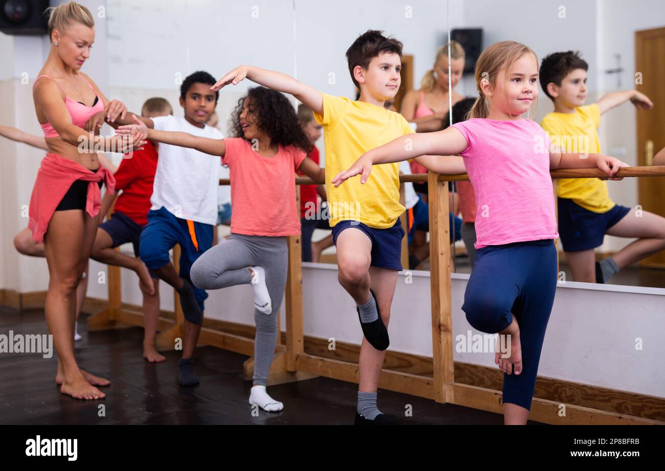 Preteen girl practicing dance movements with group of children Stock ...
