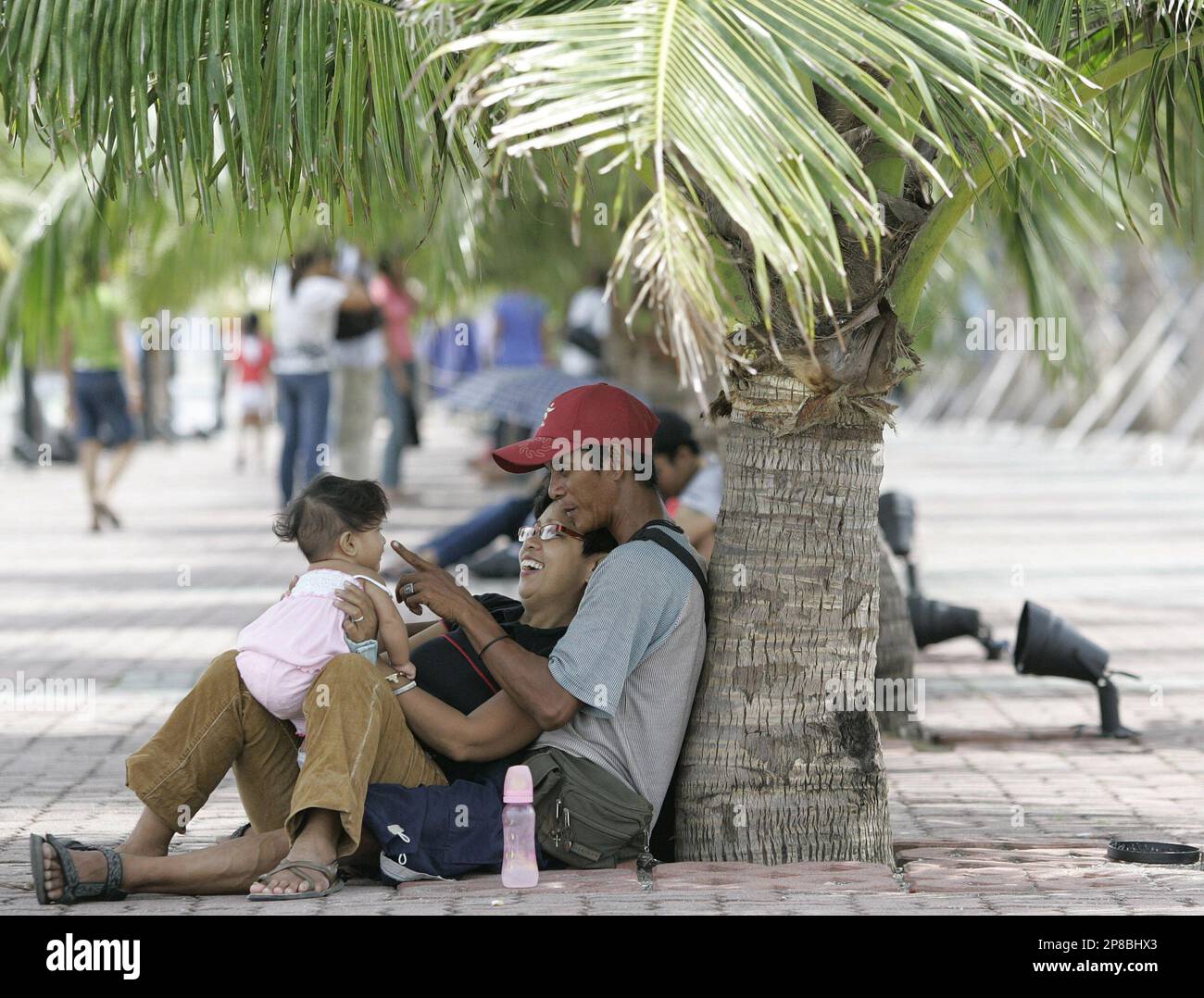 A Filipino man gestures towards his daughter during a family outing in ...