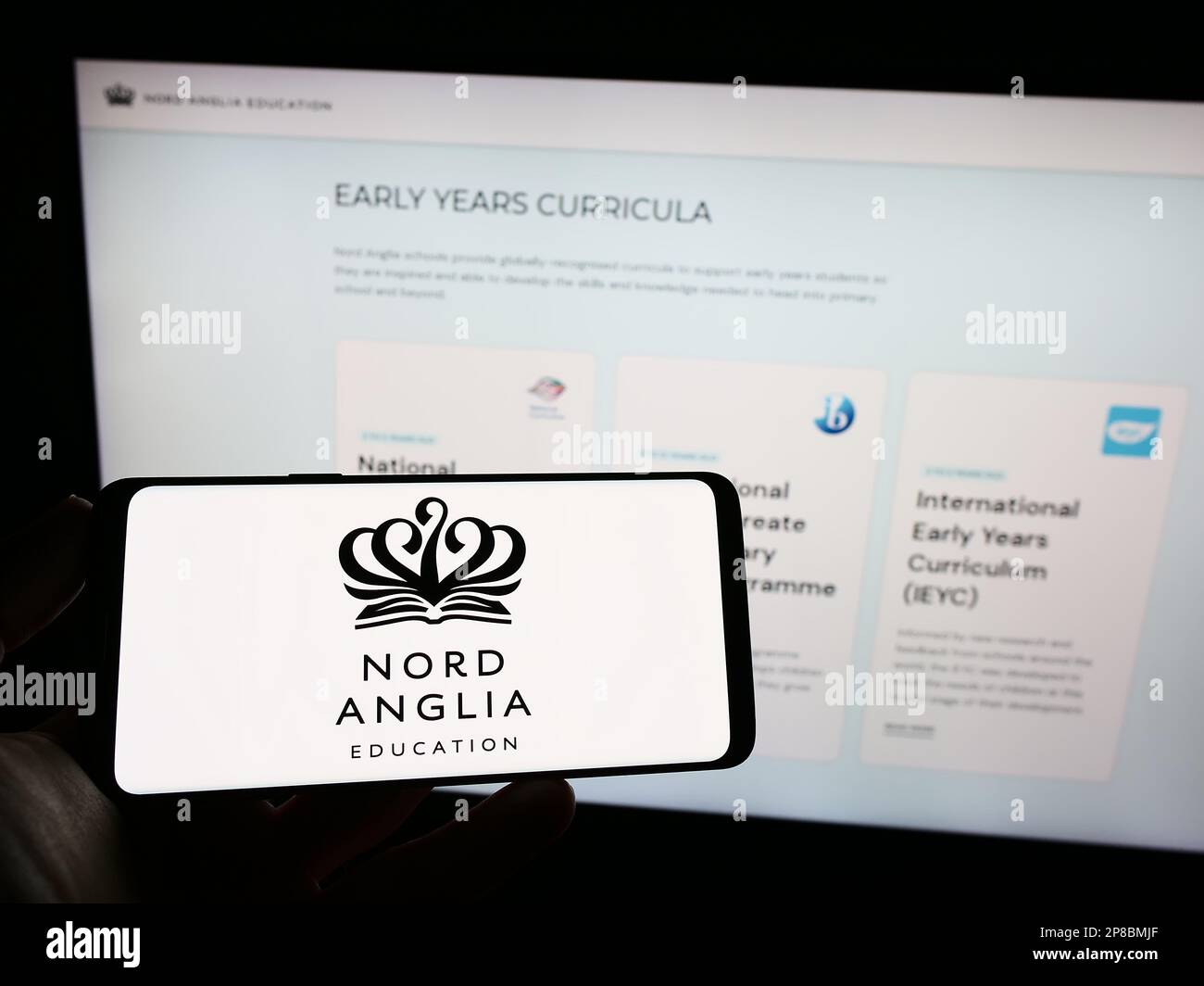 Person holding mobile phone with logo of schooling company Nord Anglia ...