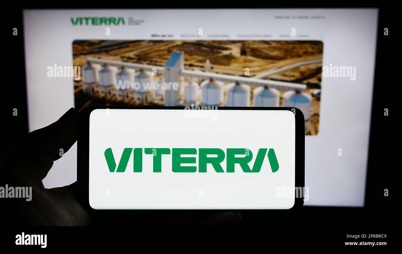 Person holding smartphone with logo of commodity trading company ...