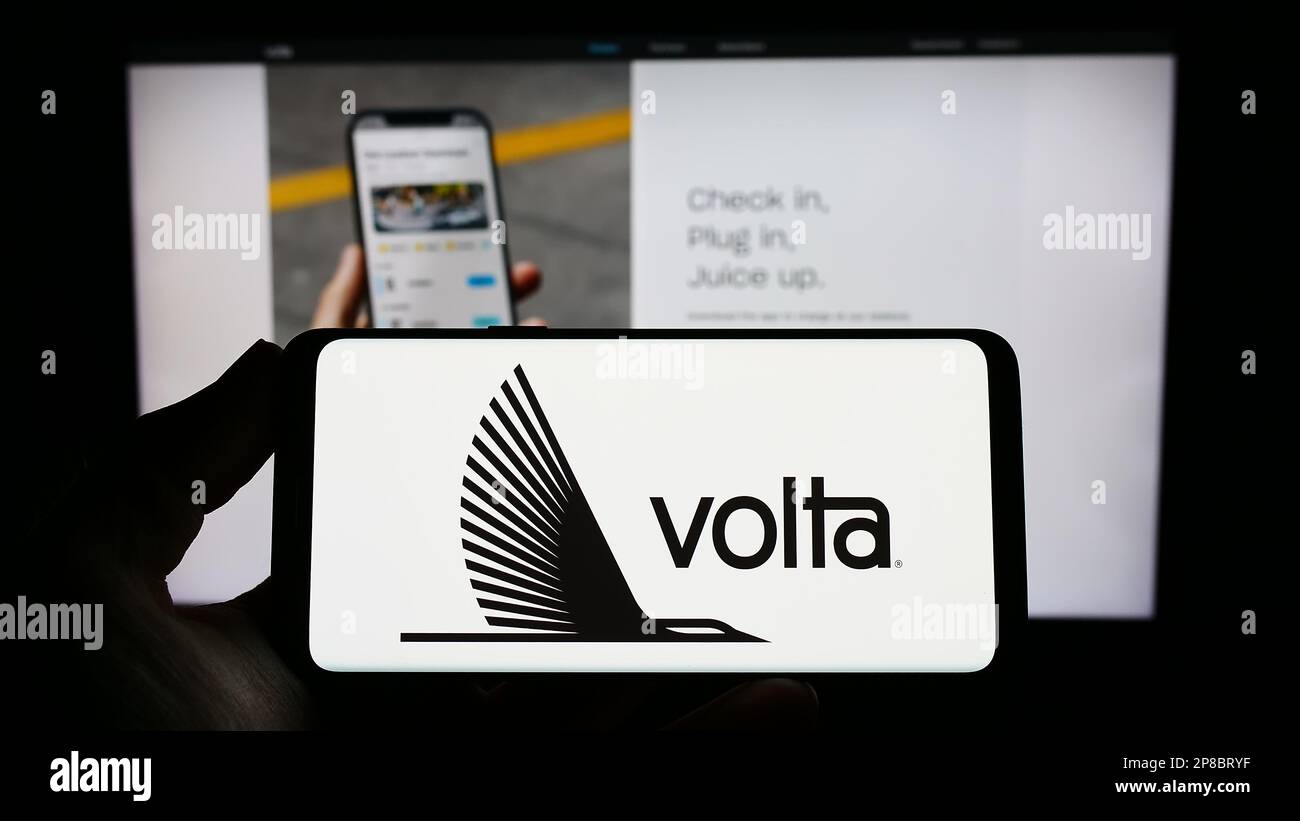 Person holding smartphone with logo of US EV infrastructure company ...