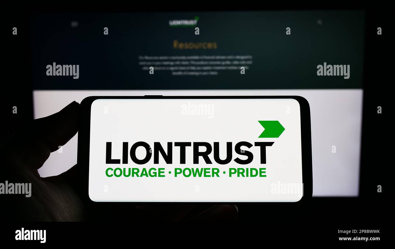 Person holding smartphone with logo of British company Liontrust Asset ...
