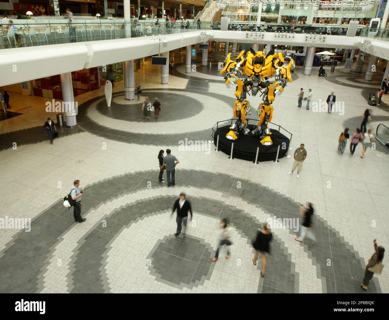 Shoppers walk past Transformers star 'Bumblebee' which stands in ...
