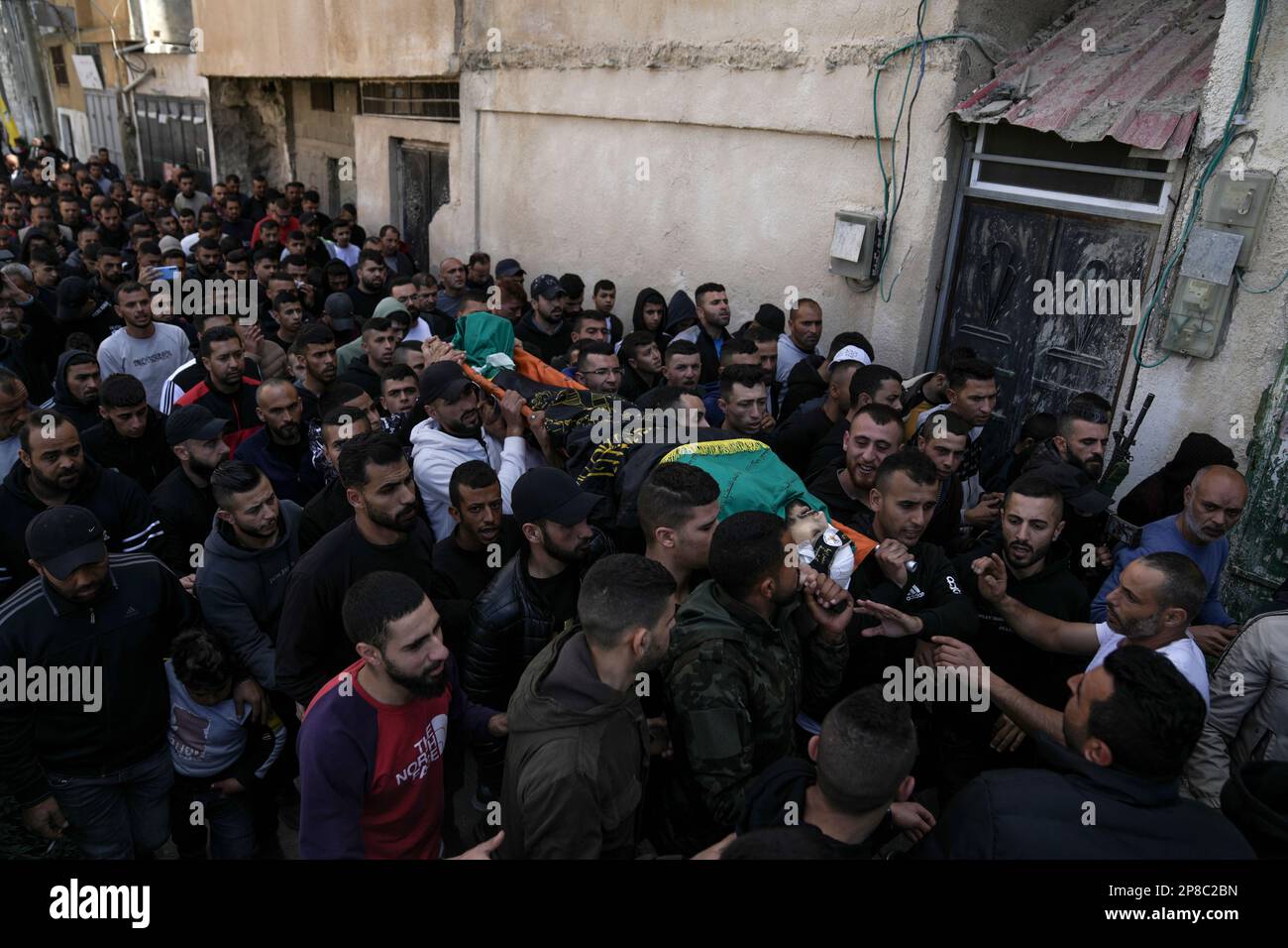 Mourners carry the body of Palestinian militant, draped in the flag of ...