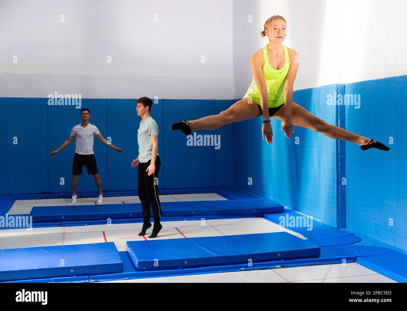 Sports girl training side split on trampoline Stock Photo - Alamy