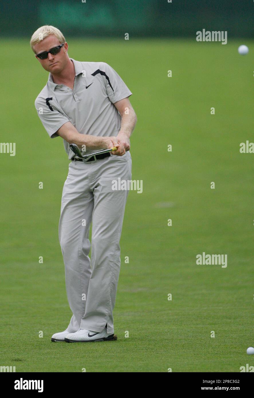 Simon Dyson of England chips onto the putting green during his practice ...