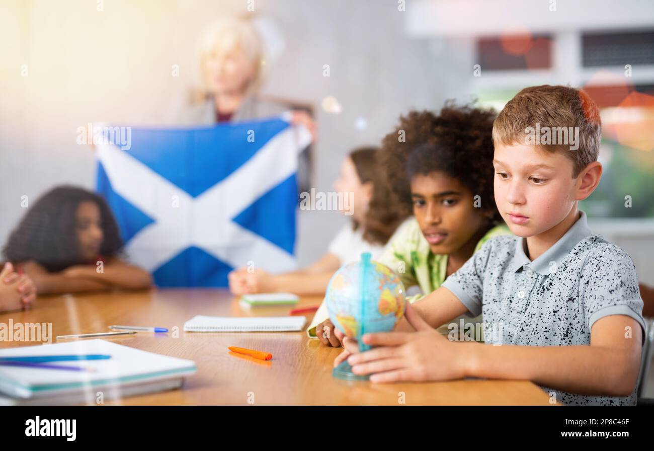 Female teacher showing scottish flag to kids in geography class Stock ...