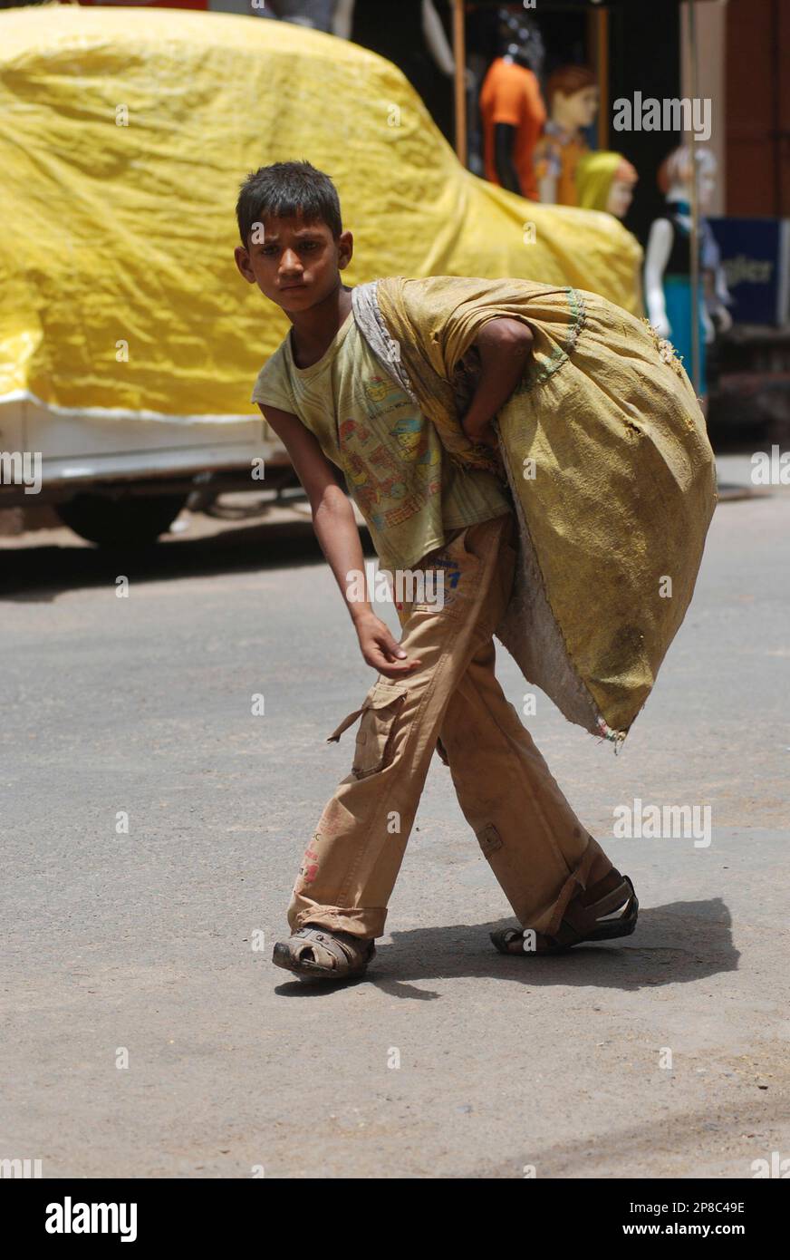 A rag picker boy looks on as he walks with his sack in Allahabad, India ...