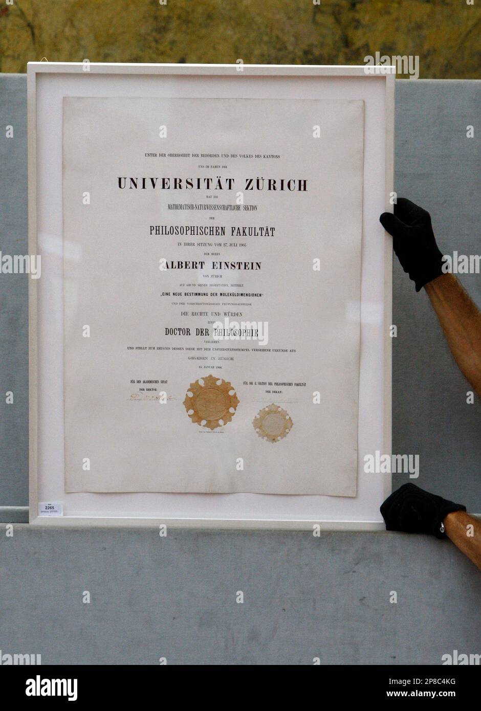 An employee holds Albert Einstein’s doctorate certificate of the ...