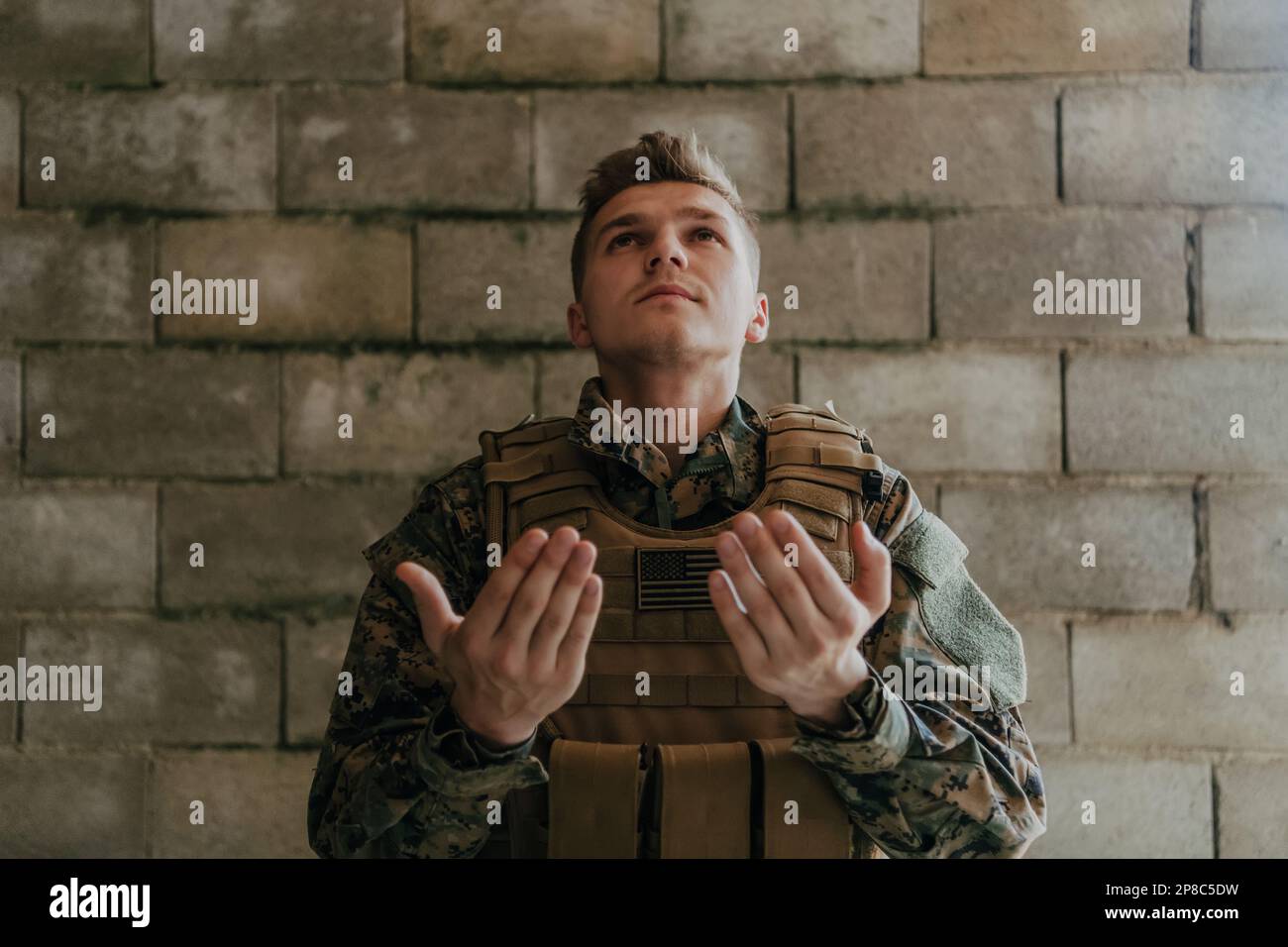 A Muslim soldier of the special forces prays to God by raising his ...