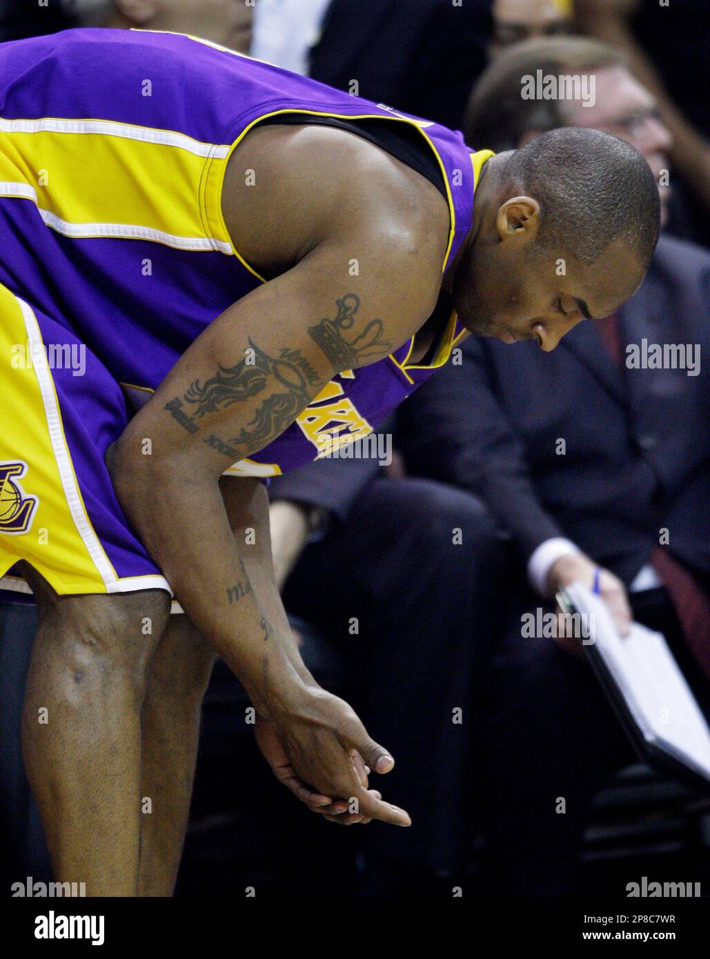 Los Angeles Lakers' Kobe Bryant holds his injured finger in the first ...
