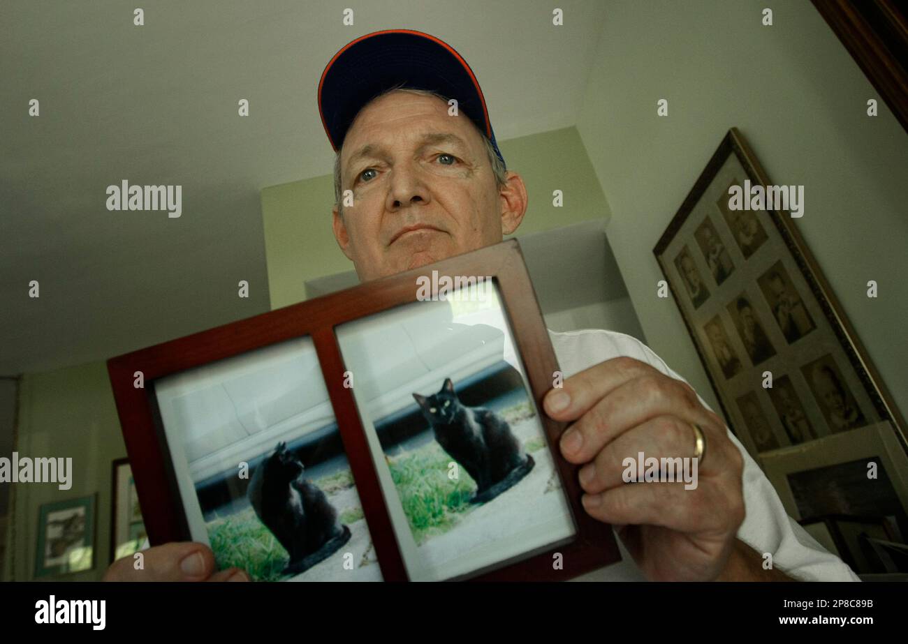 Thomas Shad displays photos of his former cat, Miss Kitty, Sunday, June ...