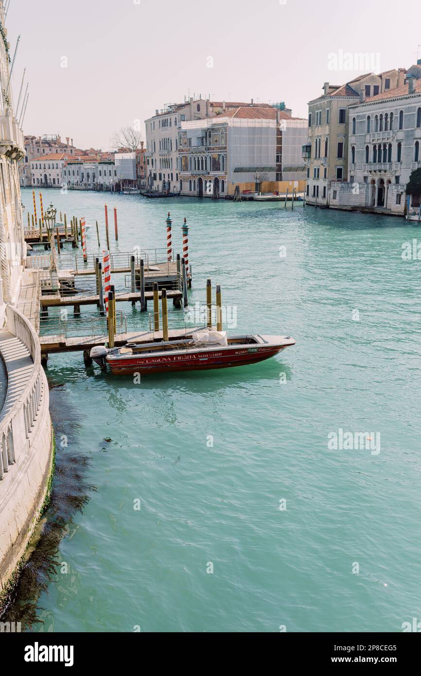 Motorboats are moored in Venice harbor with the city in the background ...