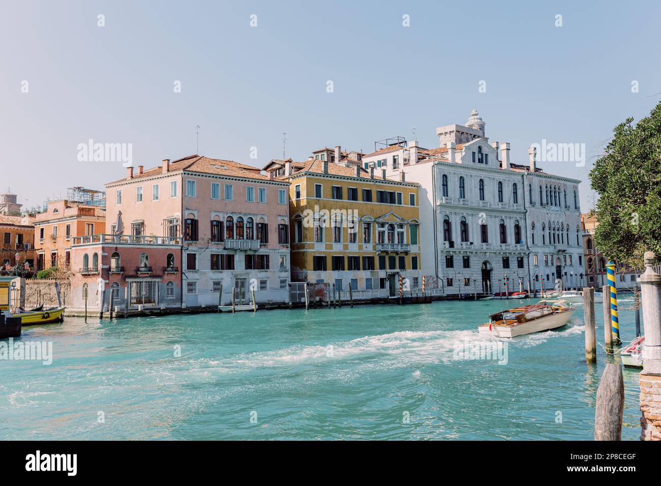 A motorboat cruises a river in Venice, with the city in the background ...