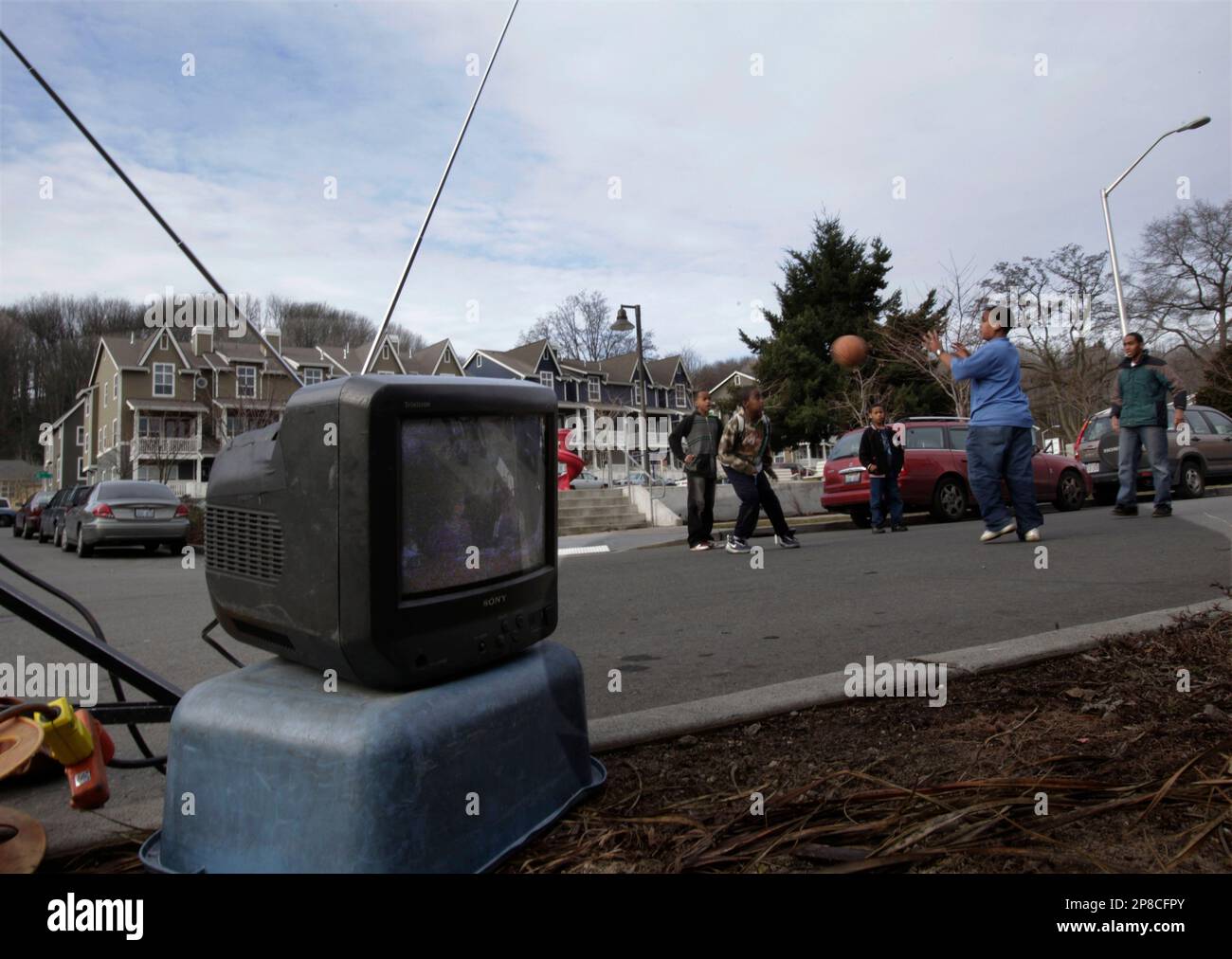 File - Children play with a ball near a television set equipped with a ...