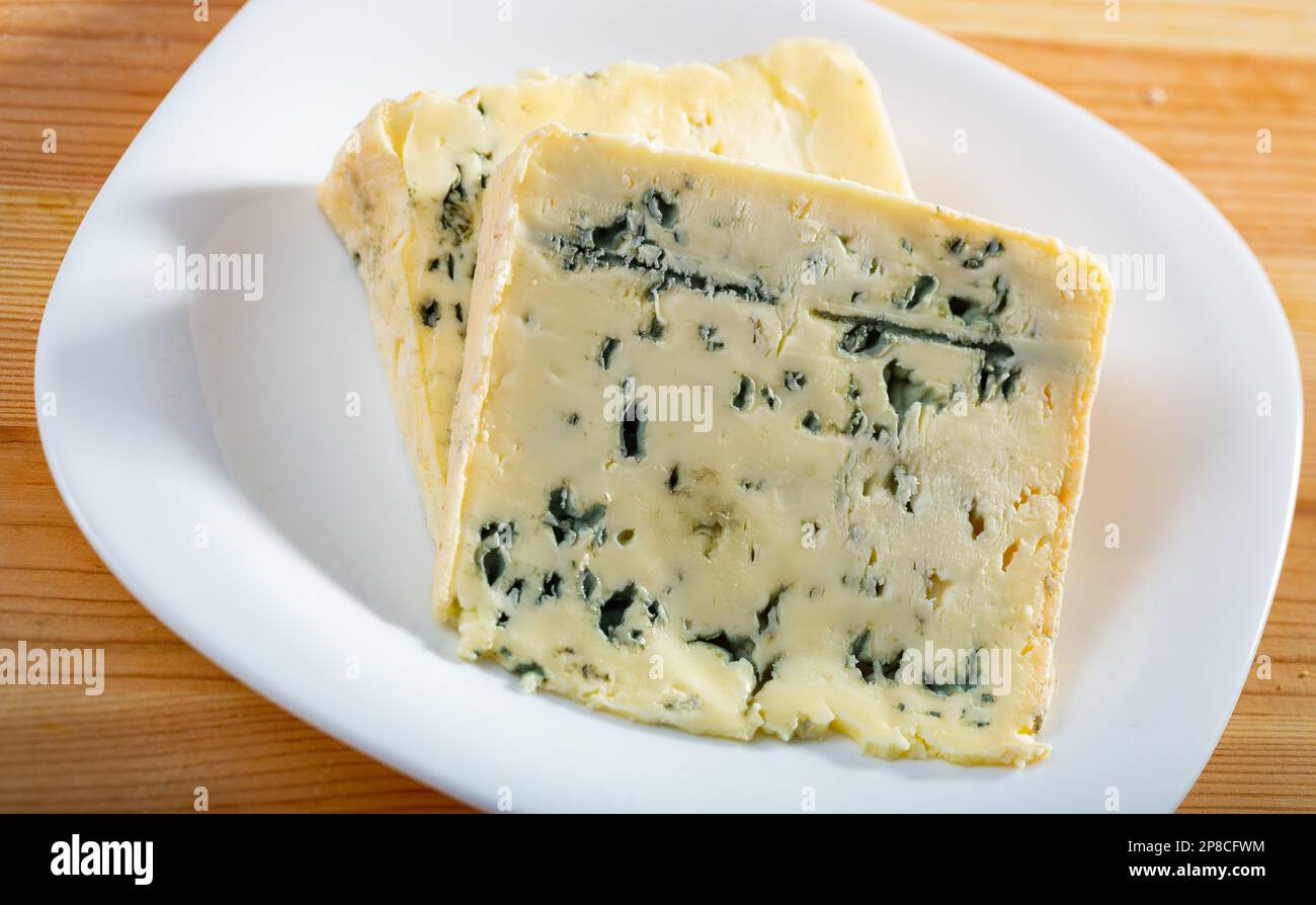 Tasty soft blue cheese with blue mold at plate, nobody Stock Photo - Alamy