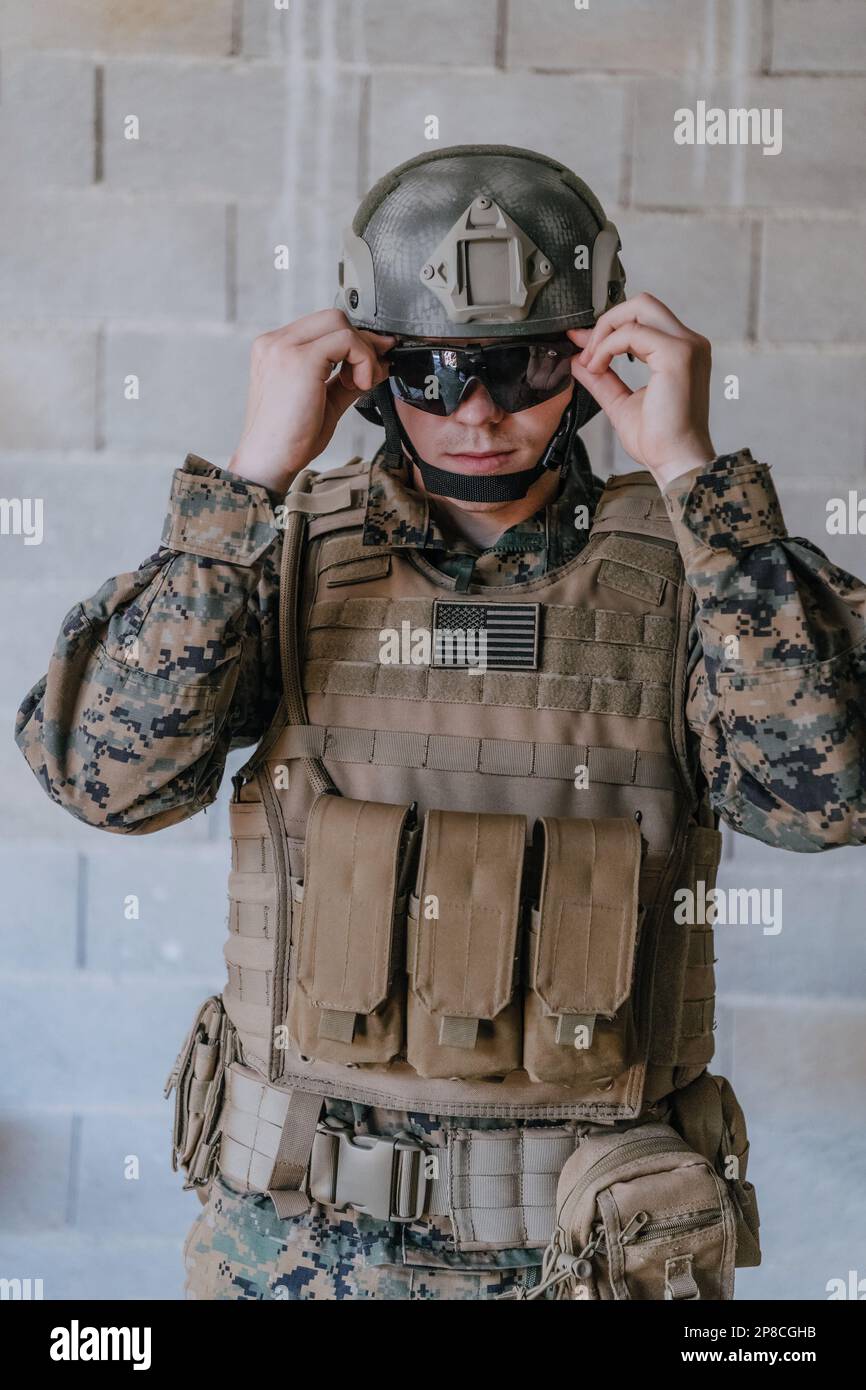 Soldier preparing tactical protective and communication gear for action ...