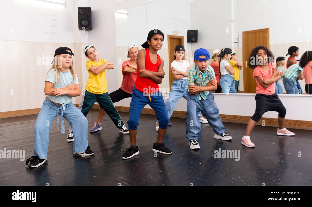 Preteen girl practicing dance movements with group of children Stock ...