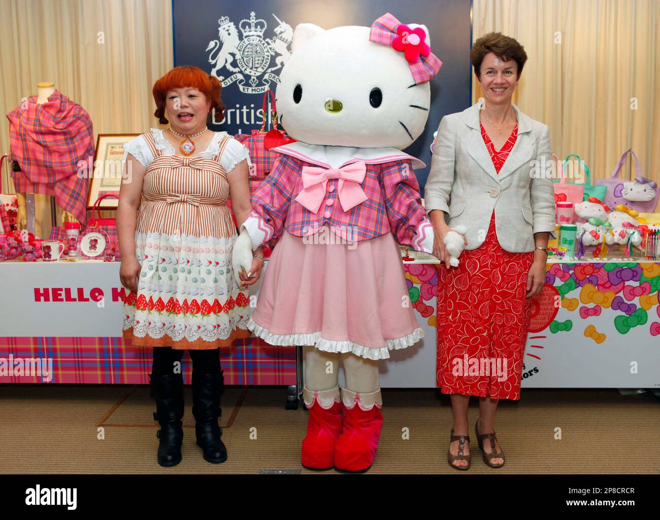 Hello Kitty in its original tartan blouse and ribbon stands with Hello ...