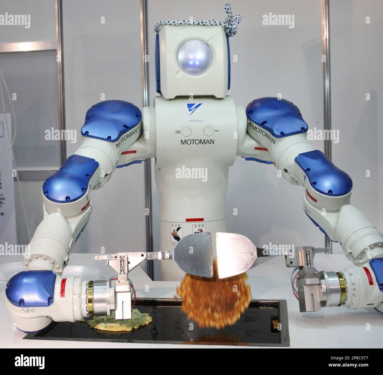 Cooking robot "Okonomiyaki Robot" turns over an okonomiyaki (Japanese ...