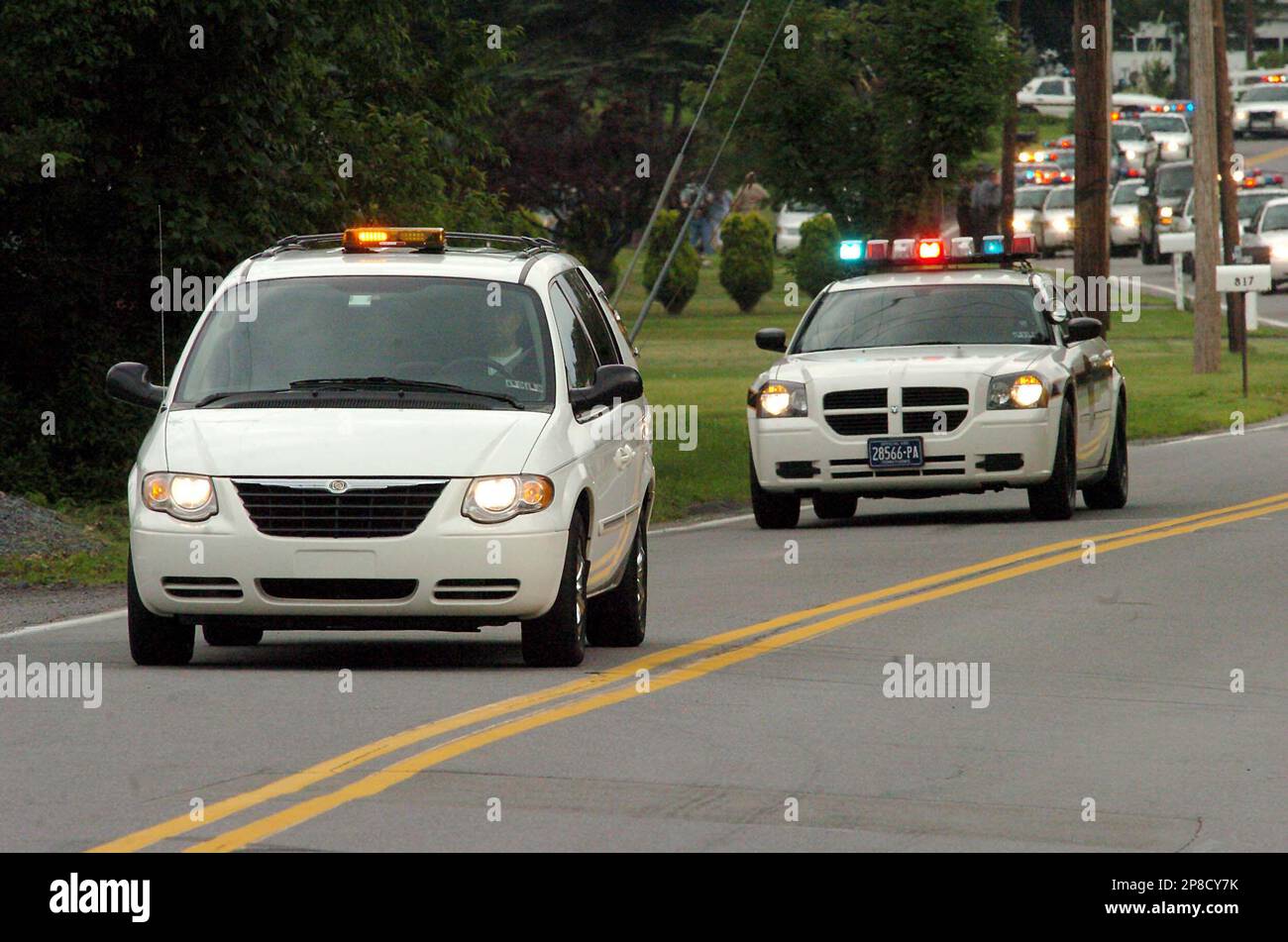 A van carrying the body of State Trooper Joshua Miller is carried past ...