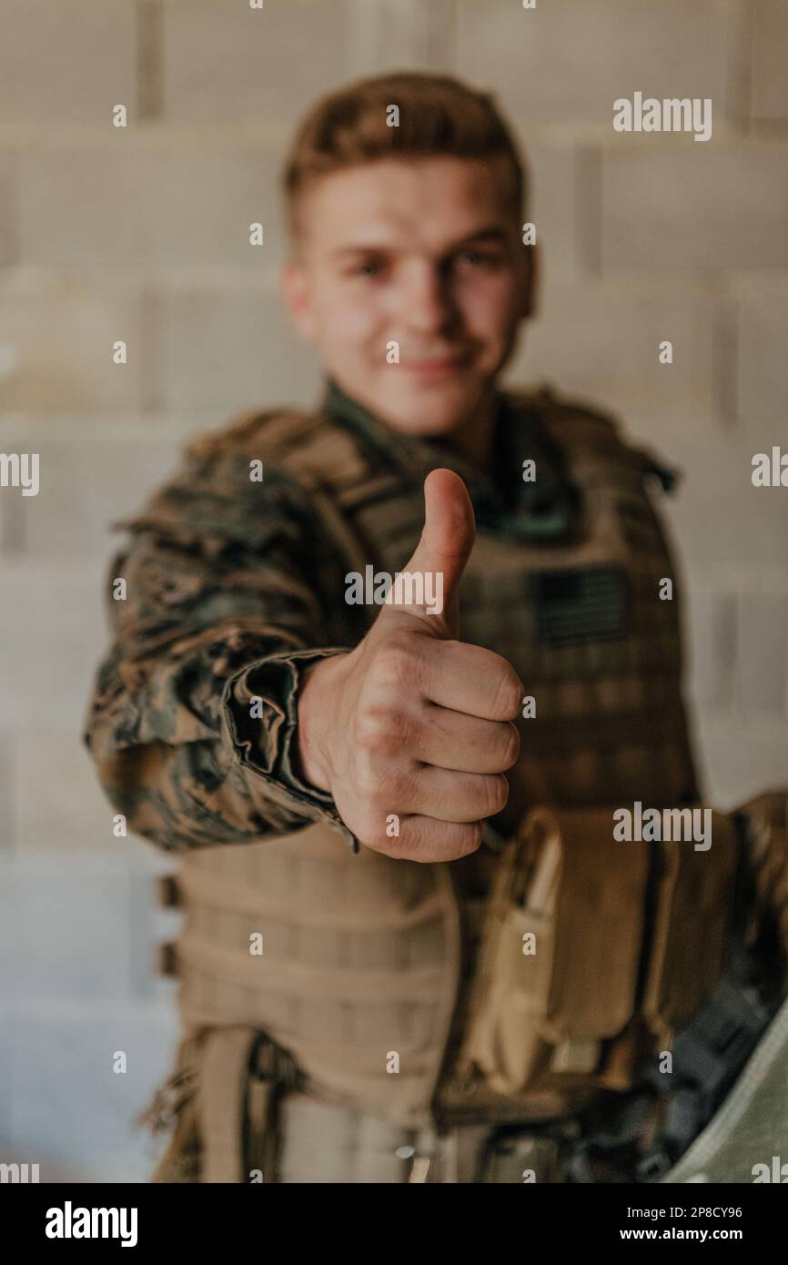 The soldier makes a gesture of success with his hand. A soldier in full ...