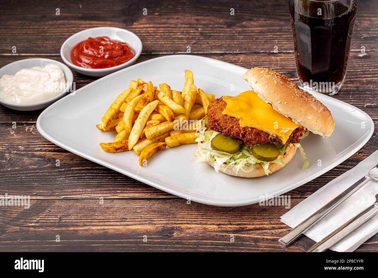 Chicken burger served with french fries and sauces in a wooden case ...