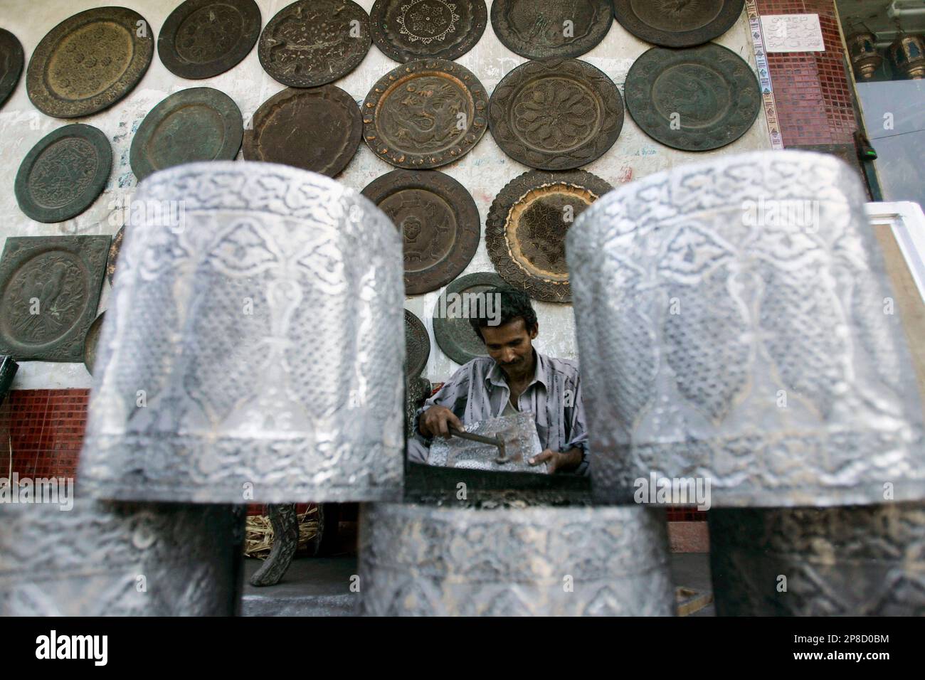 A Pakistani artisan works on a traditional handicraft at his workshop ...