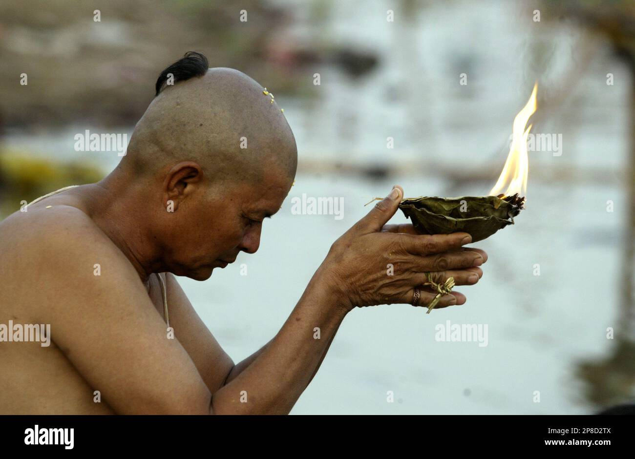 A Hindu devotee performs a ritual on Vat Savitri Purnima festival at ...