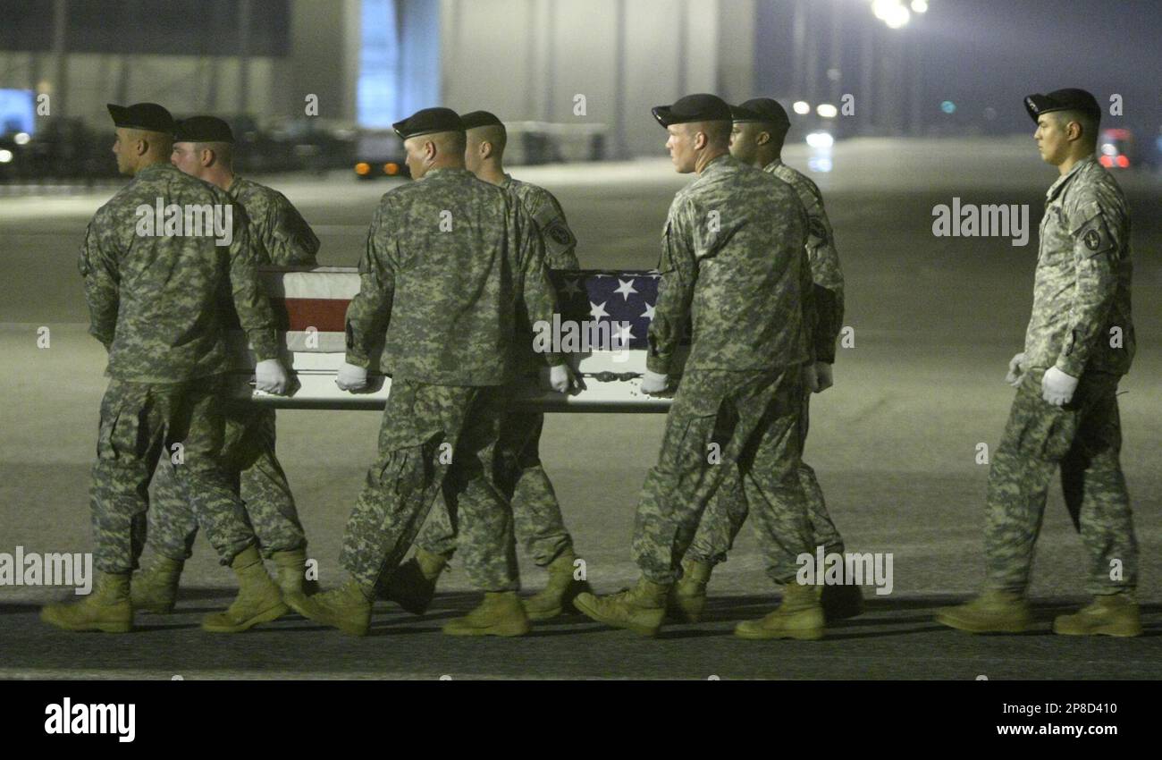 An Army carry team carries the transfer case containing the remains of ...
