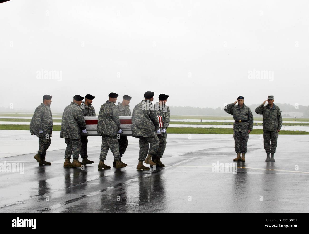 An team carries the transfer case containing the remains of Army Spc ...