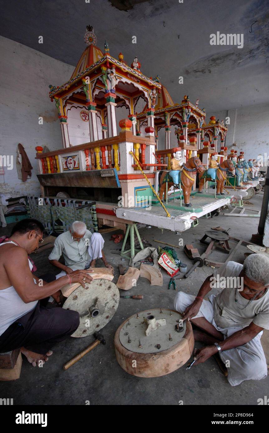 Laborers make chariot wheels for the Rath Yatra, an annual religious ...