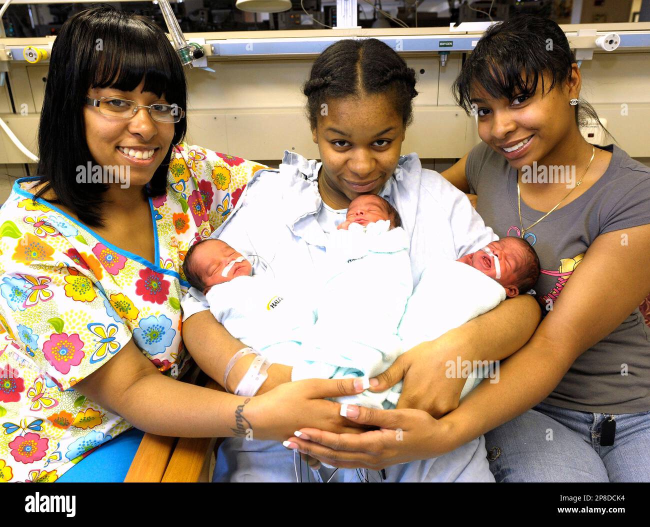 Amber Ali, center, is flanked by her triplet sisters Asia, left, and ...