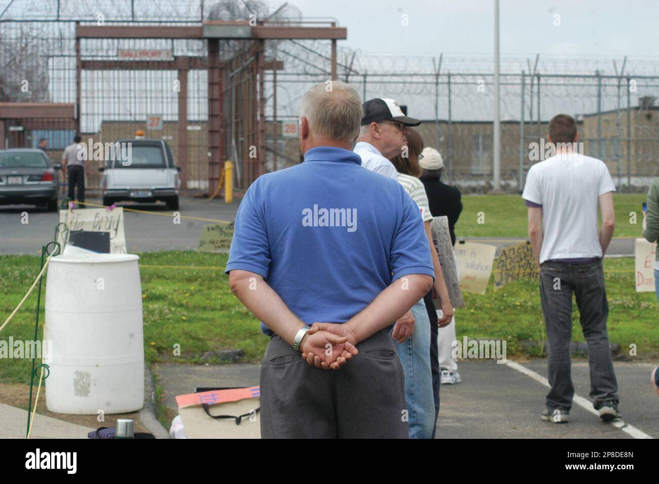 An unidentified protestor looks on as a hearse waits to enter the ...