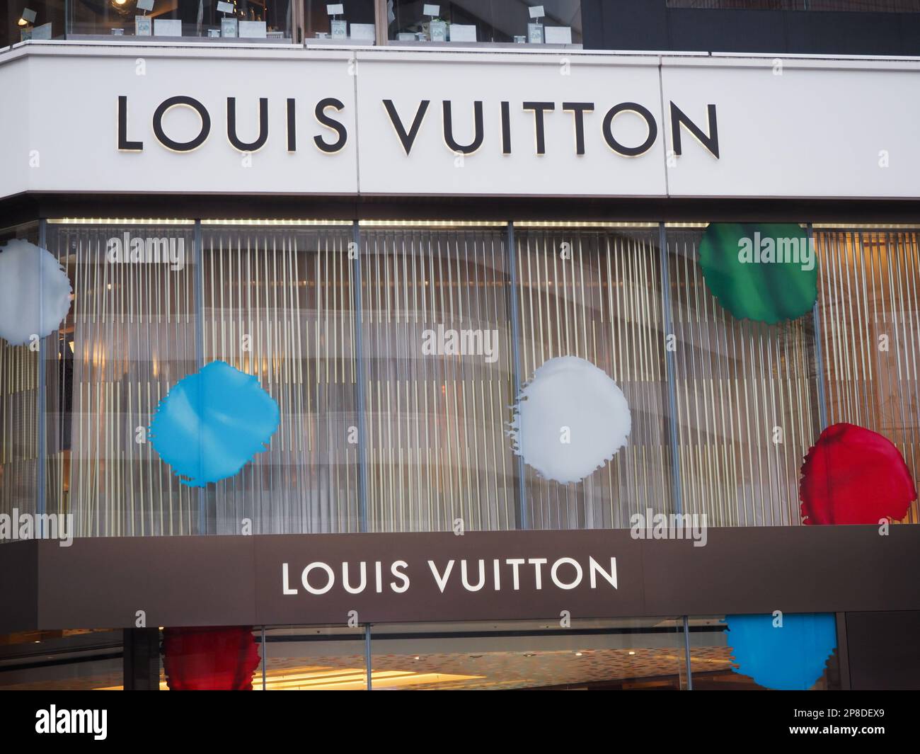 Signs and Yayoi Kusama motifs on a building containing a Louis Vuitton ...