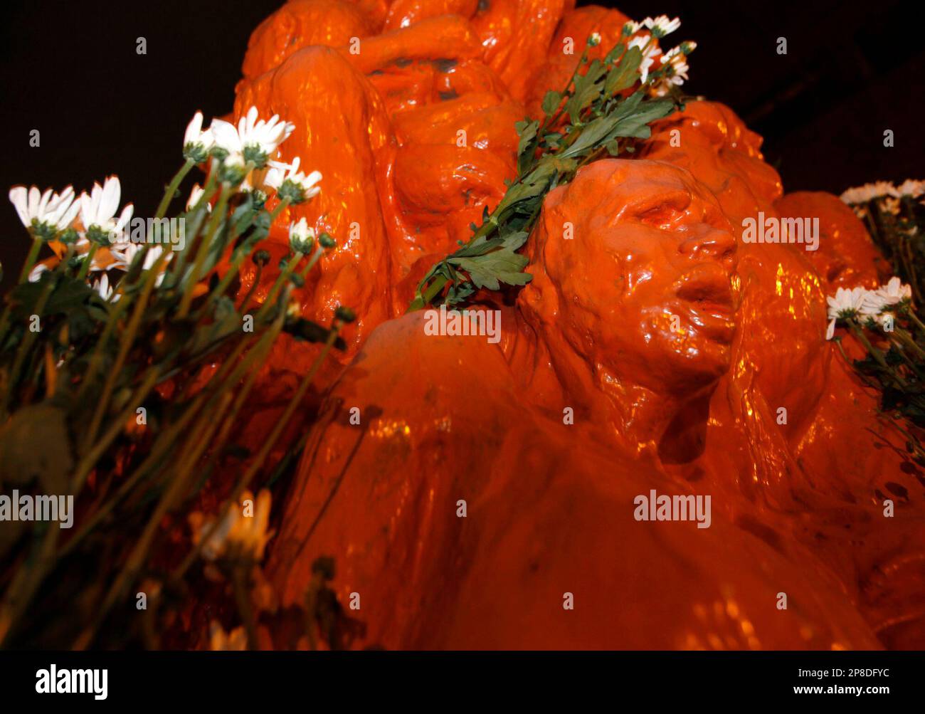 Flowers are placed on the "Pillar of Shame " statue, which commemorates ...