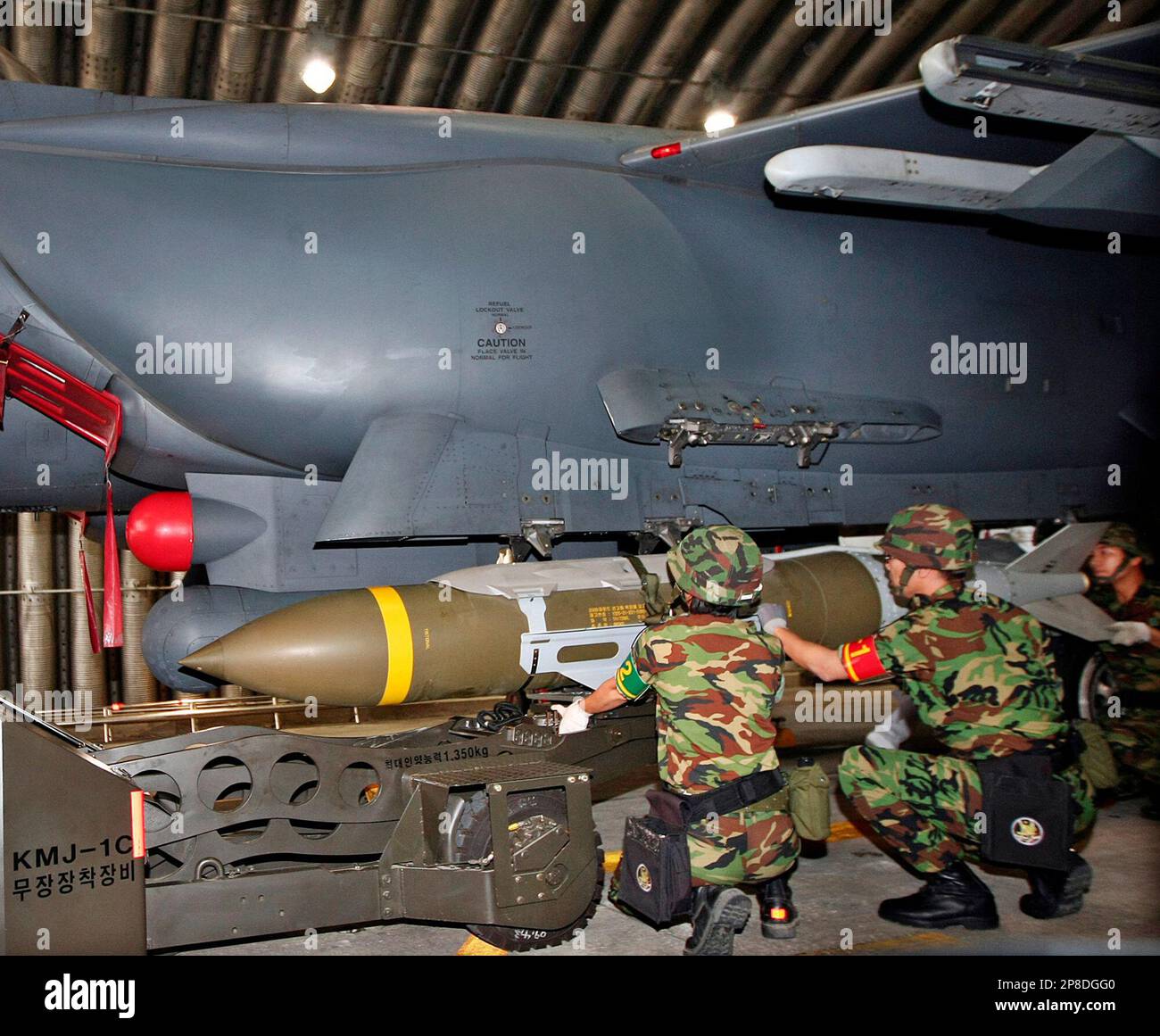 South Korean Air Force soldiers attach a Joint Direct Attack Munition ...