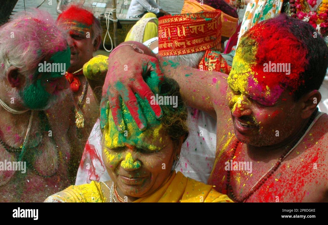 Hindu devotees smear color on each other after immersing an idol of ...