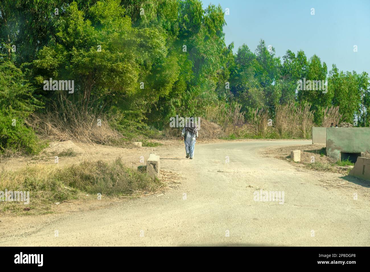 A village man walking beside road in sunny day Stock Photo - Alamy