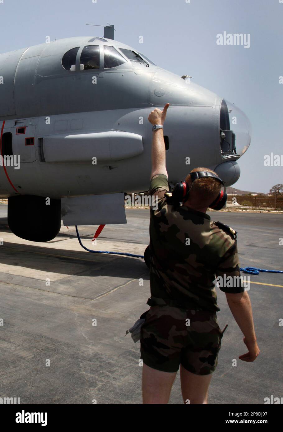 A member of the ground crew gives a thumbs up signal to the pilot of an ...