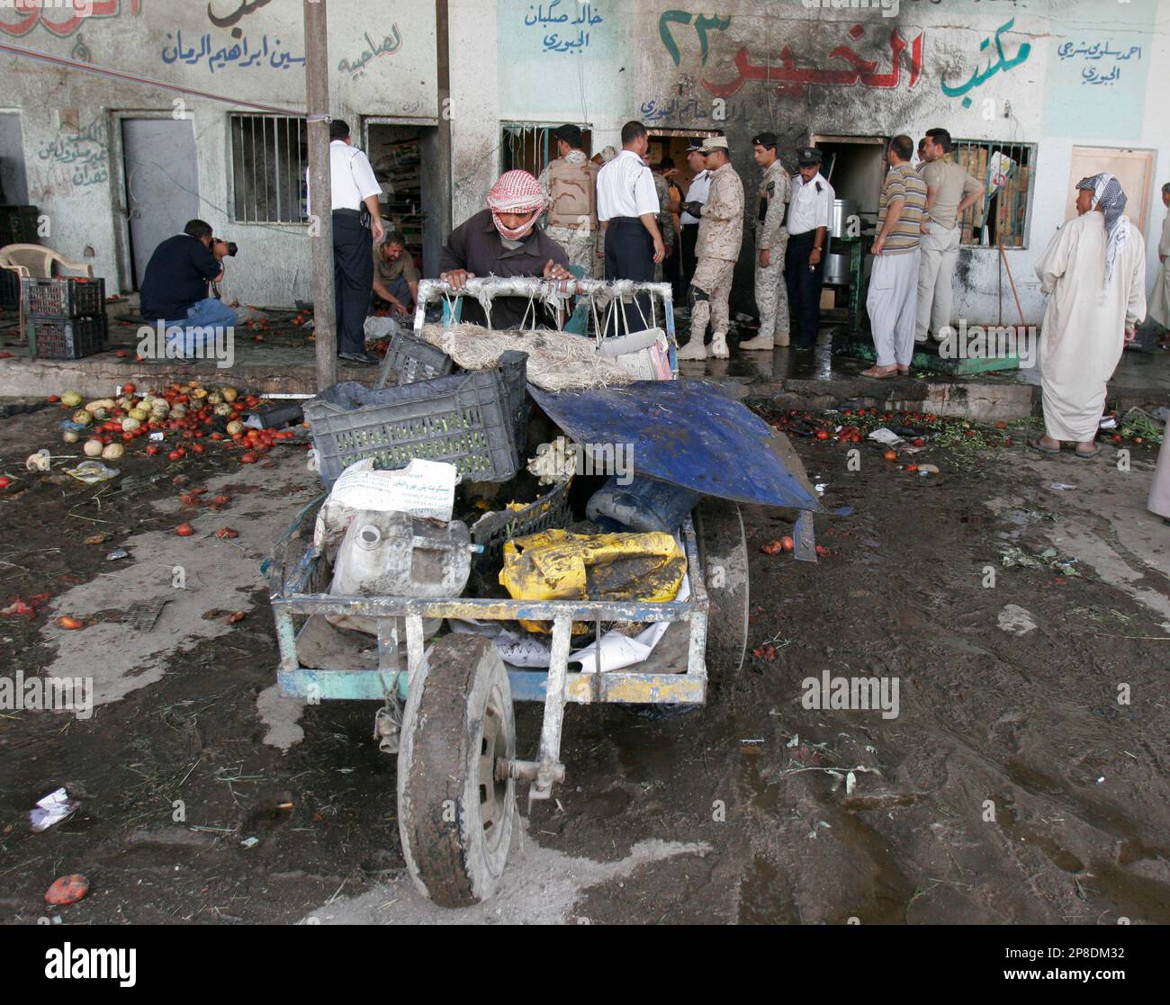 A merchant pushes a cart away from the scene after a bomb exploded at a ...