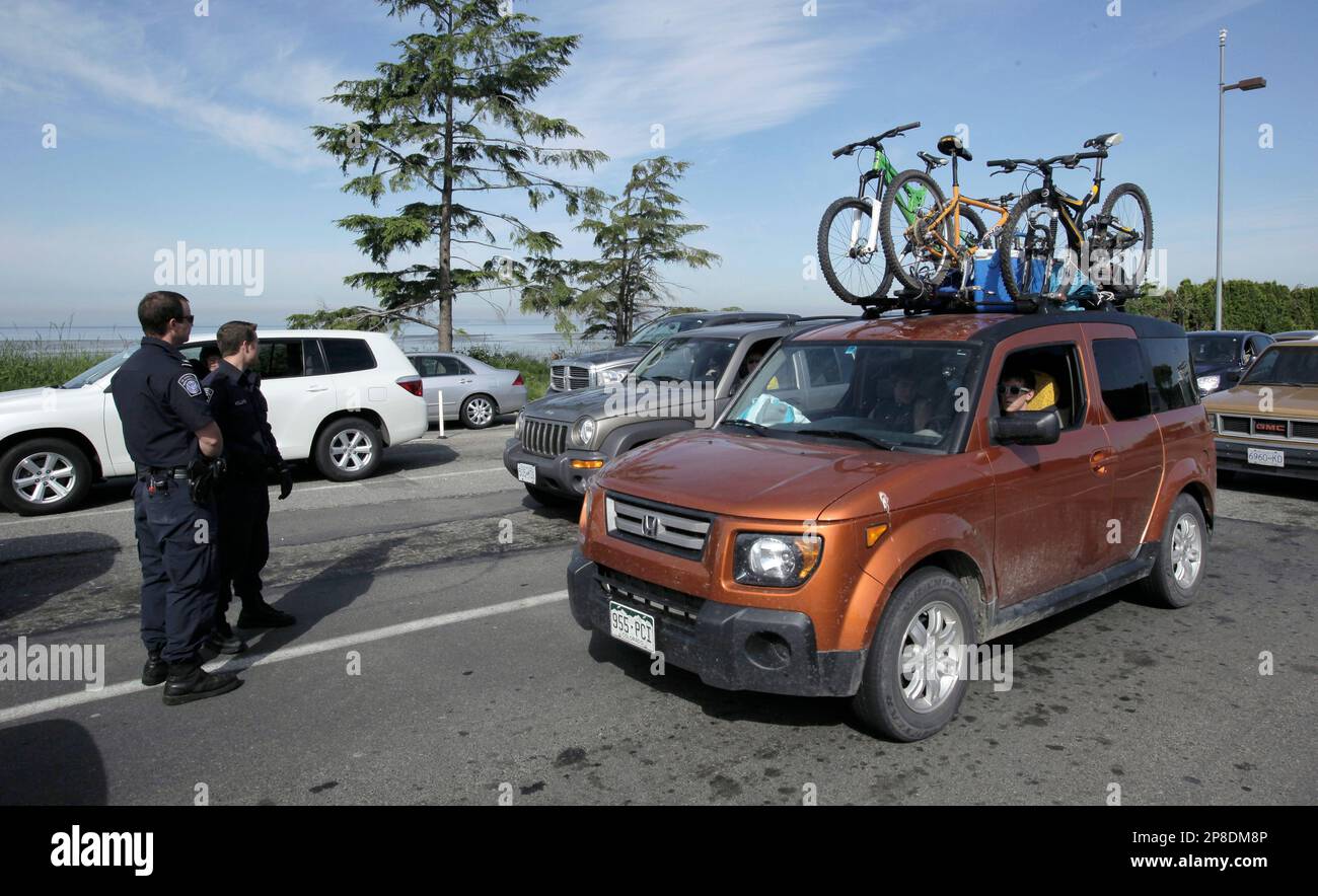 U.S. Customs and Border Patrol officers look on as cars wait in line to ...