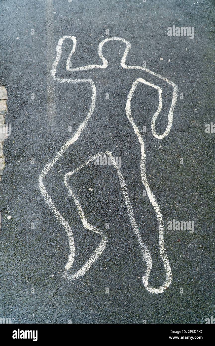 A vertical shot of a drawn outline of a person on the road. Road ...