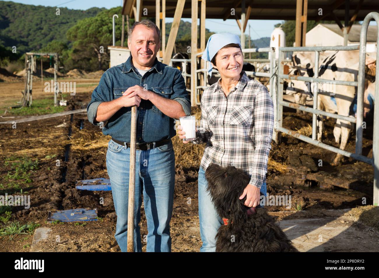 Couple farmers are standing with dog Stock Photo - Alamy