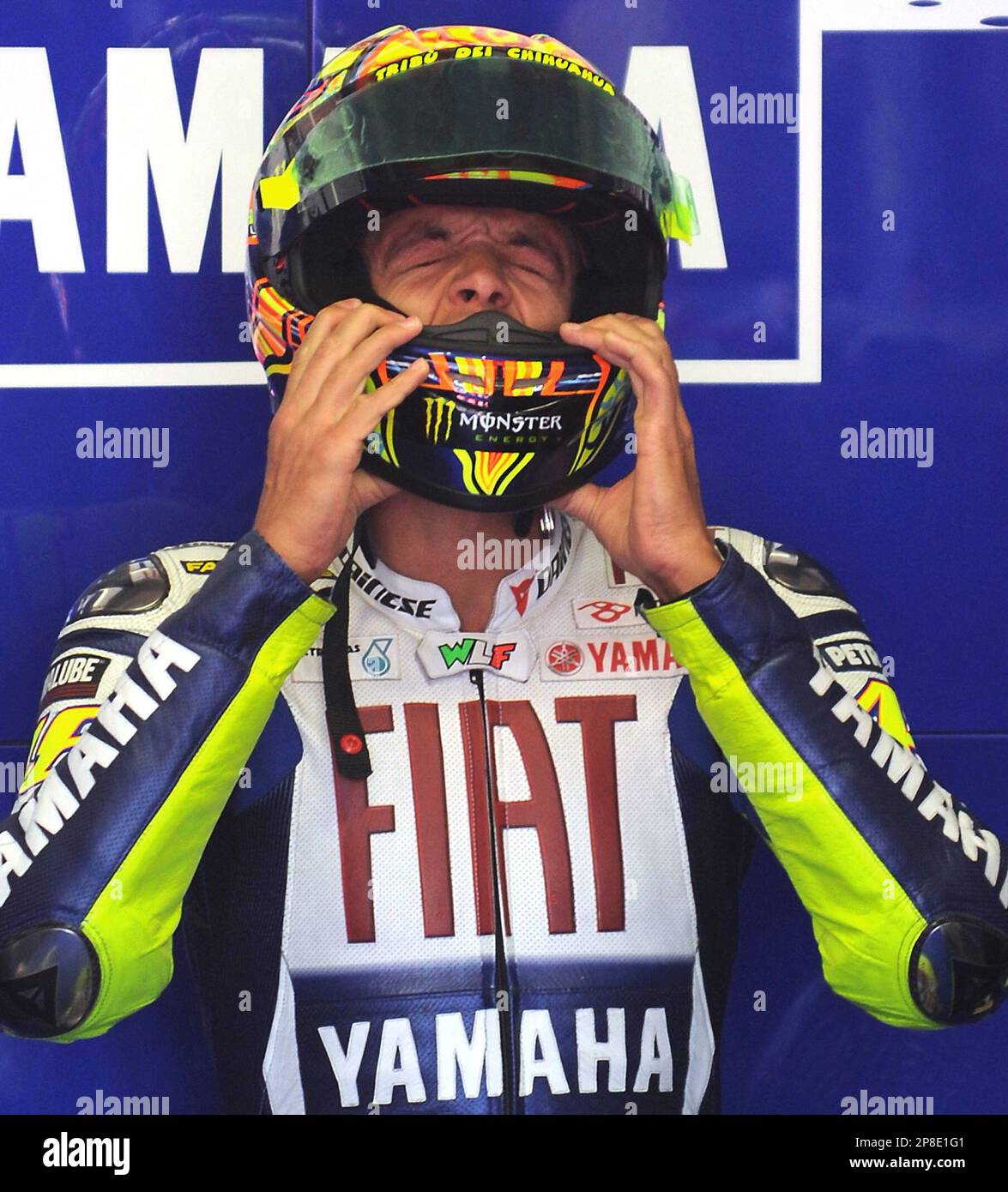 Yamaha rider Valentino Rossi, of Italy, puts on his helmet in the pit ...