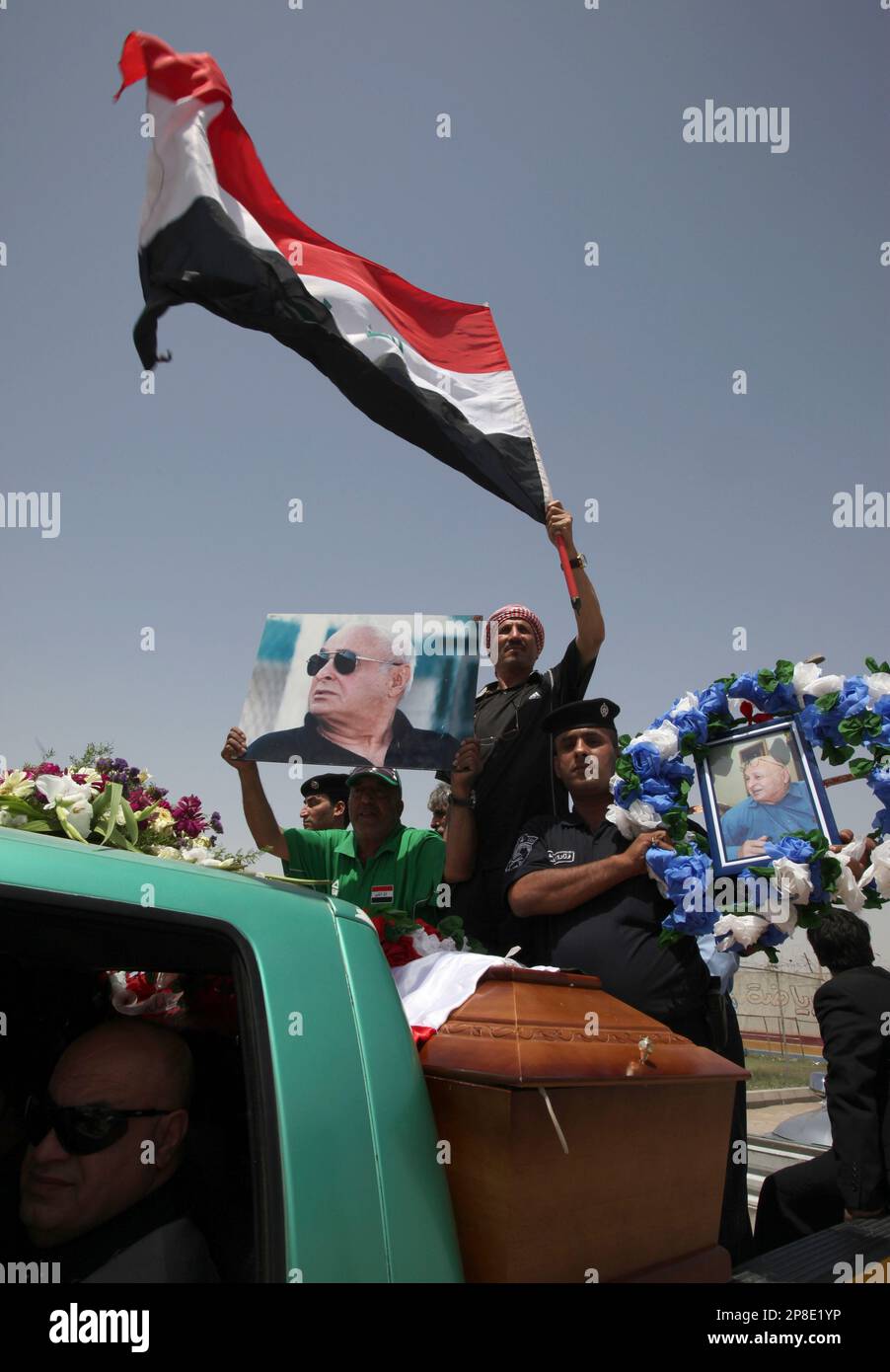 Men carry portraits of Iraqi national football coach Emmanuel Baba ...